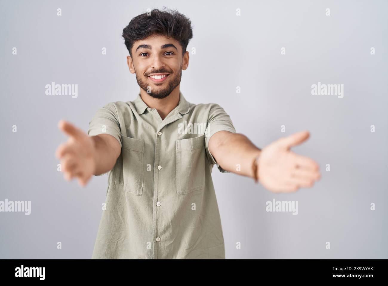 Arab man with beard standing over white background smiling cheerful ...