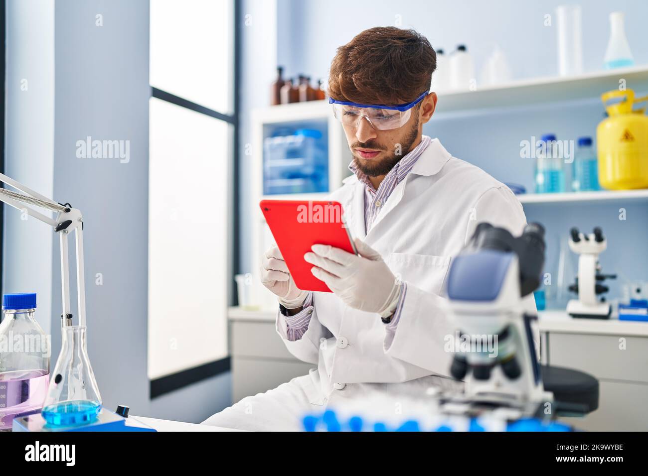 Young arab man scientist using touchpad working at laboratory Stock Photo - Alamy