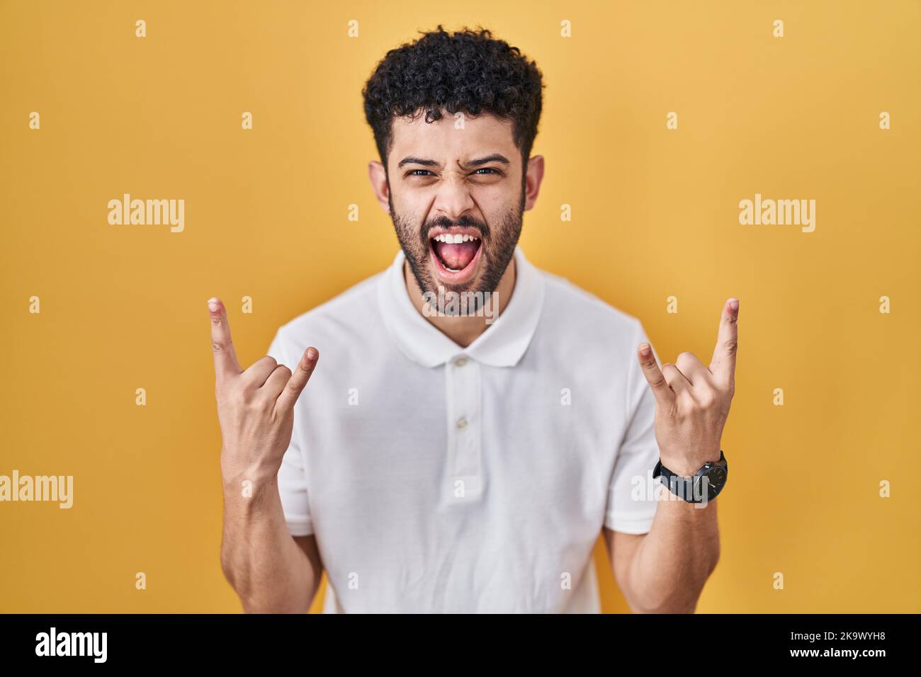 Arab man standing over yellow background shouting with crazy expression ...