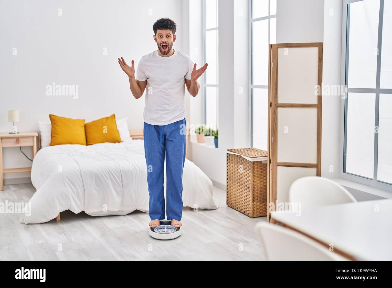 Arab man looking at weight machine to balance weight loss celebrating ...