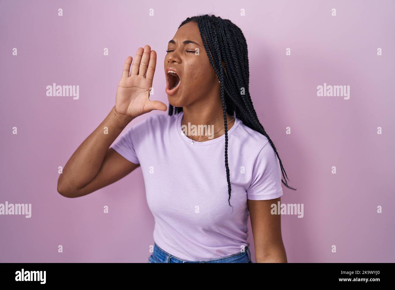 African american woman with braids standing over pink background ...