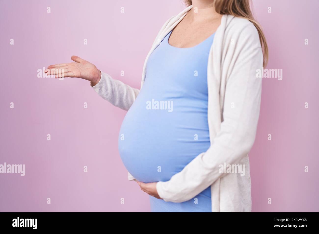 Young pregnant woman expecting a baby, touching pregnant belly ...