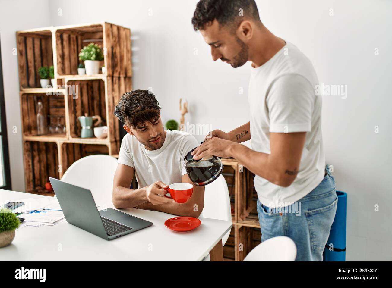 Two hispanic men couple pouring coffee having breakfast at home Stock ...