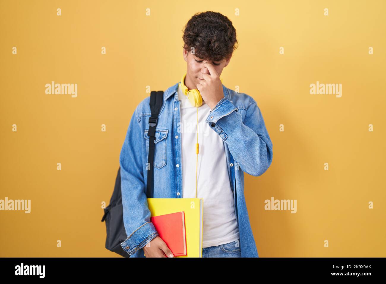 Hispanic teenager wearing student backpack and holding books tired ...