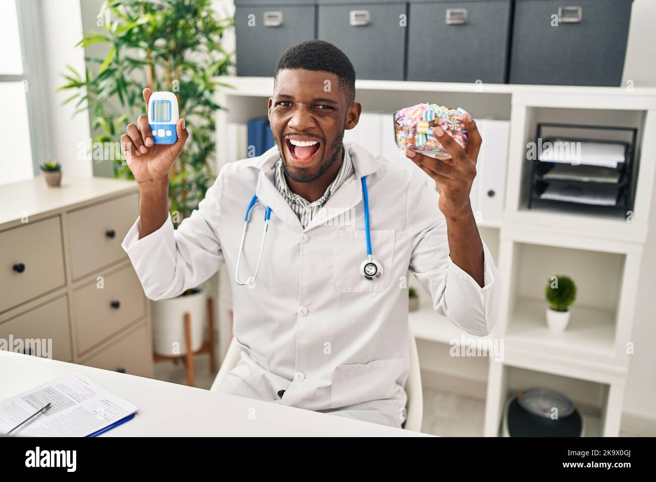 African american doctor man using glucose meter celebrating crazy and ...