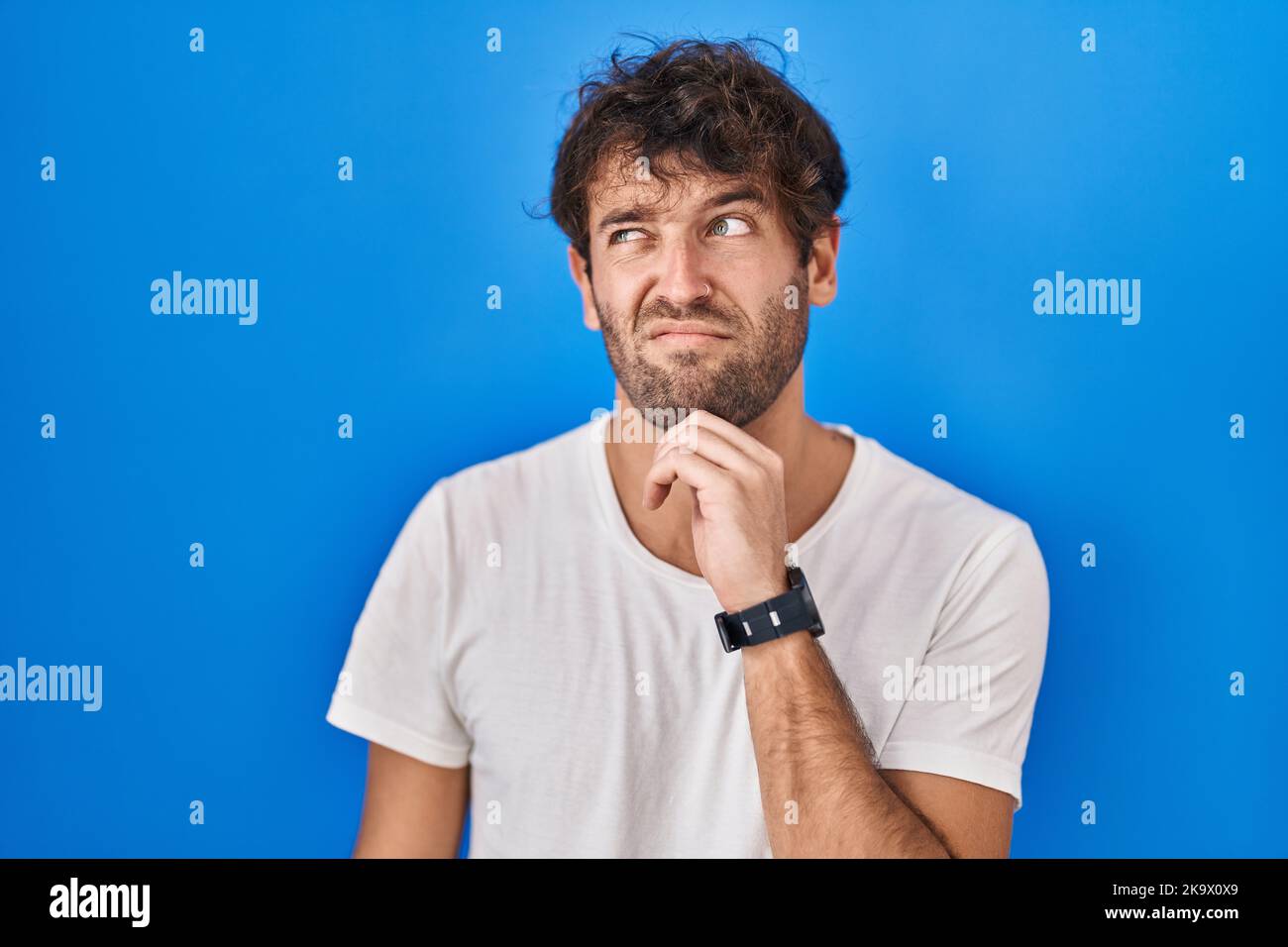 Hispanic young man standing over blue background thinking worried about ...