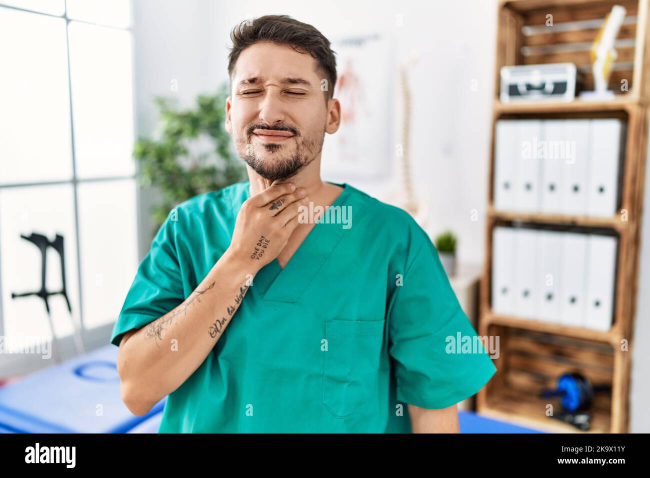 Young physiotherapist man working at pain recovery clinic touching ...