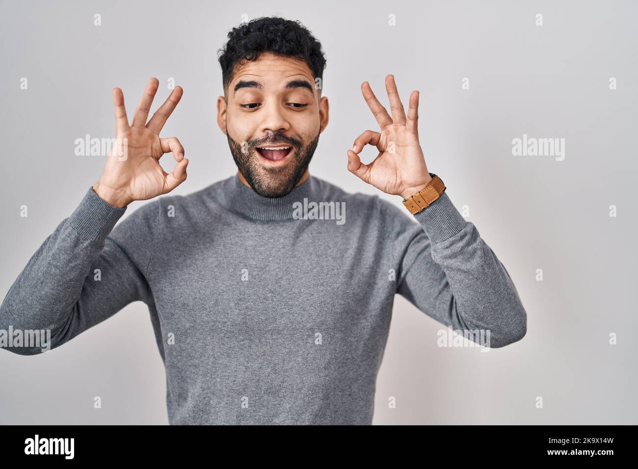 Hispanic man with beard standing over white background looking ...