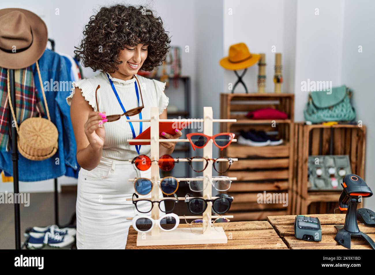 Young middle east shopkeeper woman smiling happy working at clothing ...