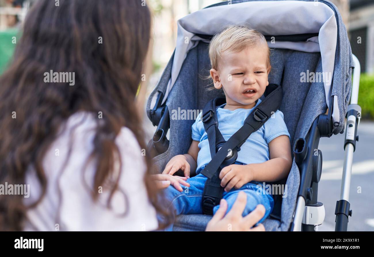 Mother and son sitting on stroller baby crying at street Stock Photo ...