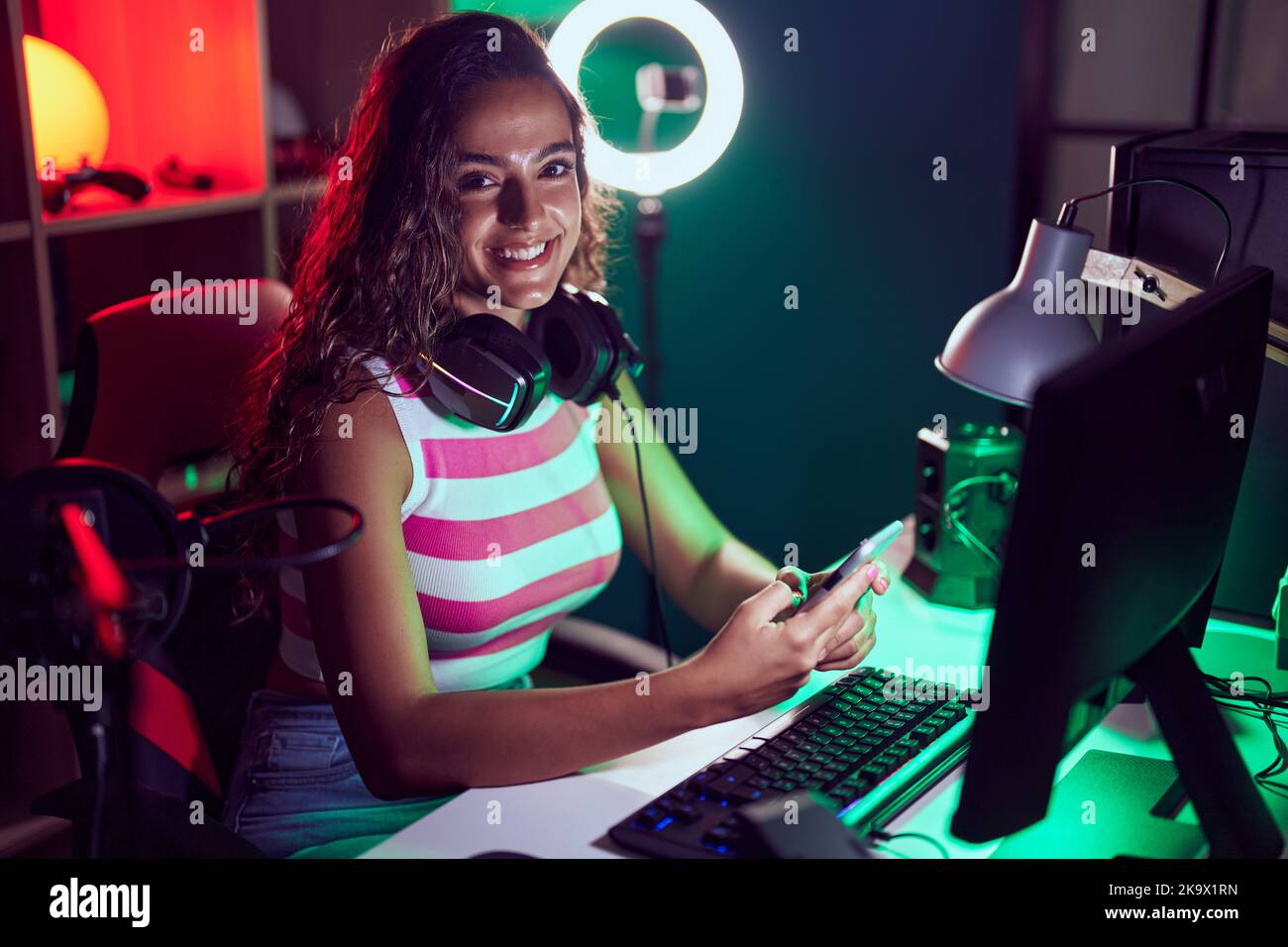 Young beautiful hispanic woman streamer using computer and smartphone ...