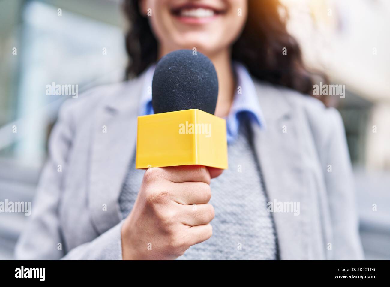 Young hispanic woman reporter working using microphone at street Stock ...