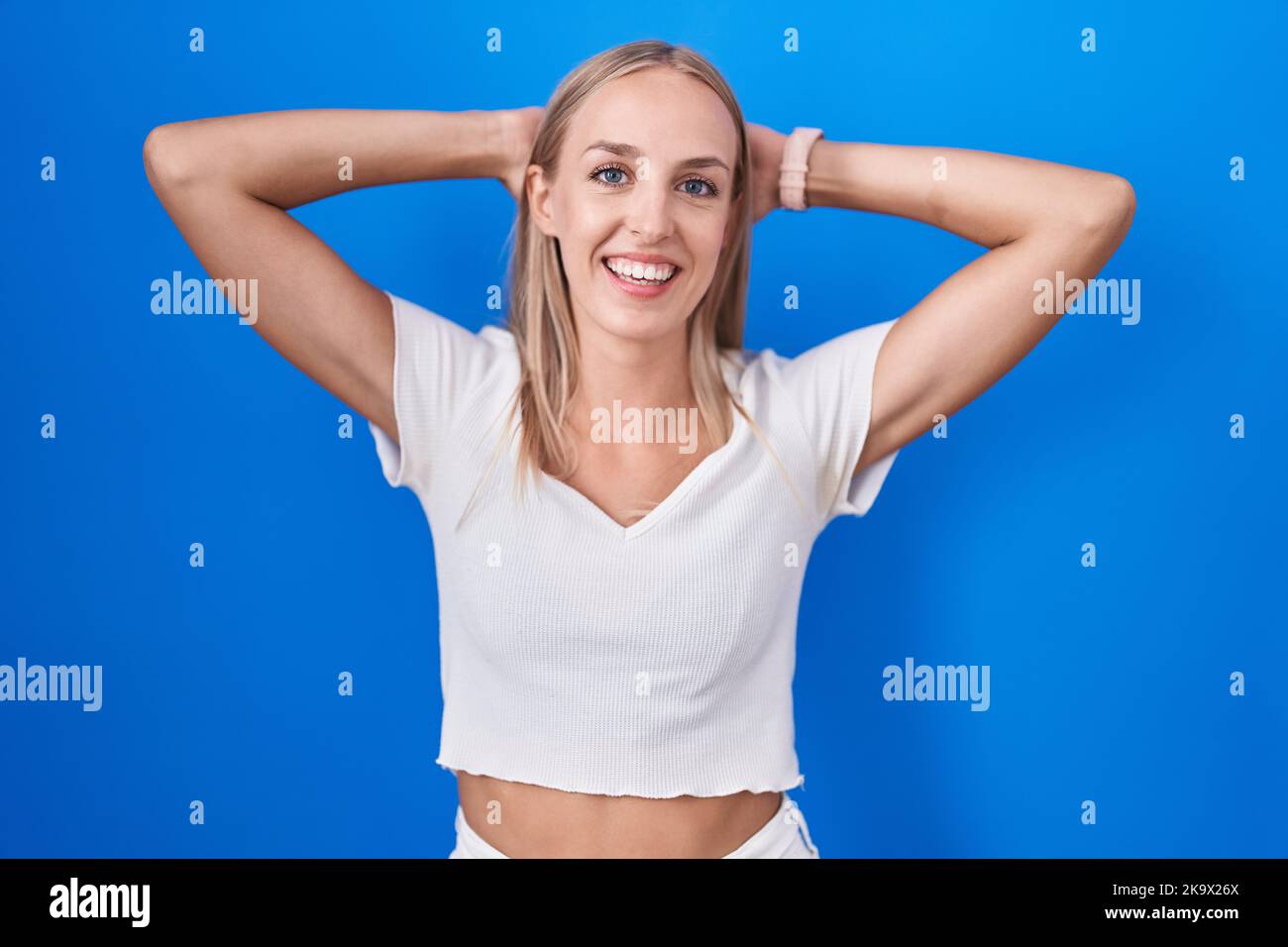Young caucasian woman standing over blue background relaxing and ...