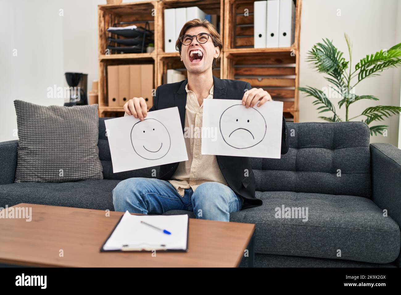 Young therapist man working on depression holding sad to happy emotion ...