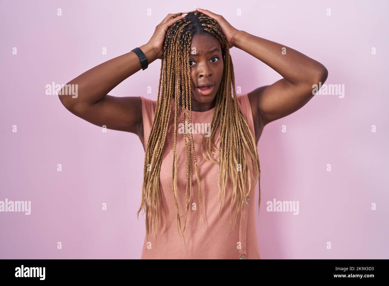 African american woman with braided hair standing over pink background ...