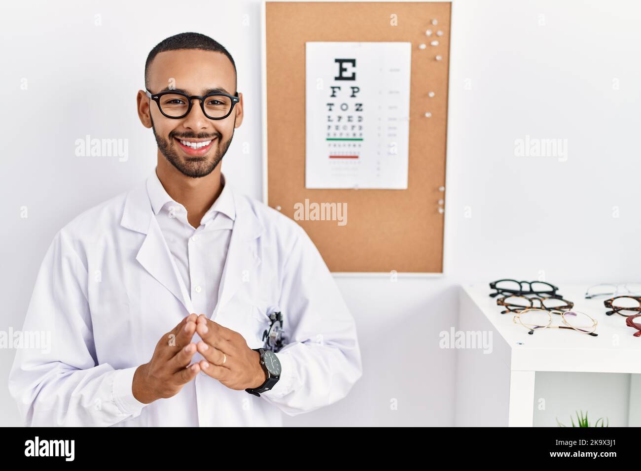 African american optician man standing by eyesight test hands together ...
