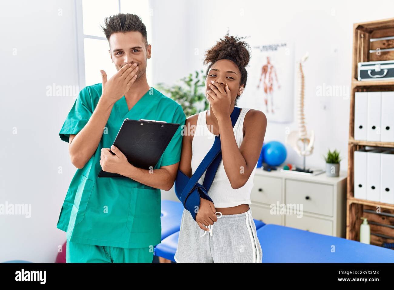 Physiotherapist working with patient wearing arm on sling at ...