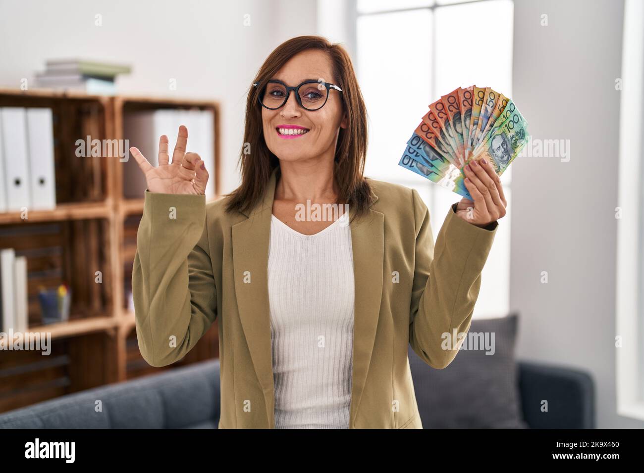 Middle age woman working at consultation office holding australian ...