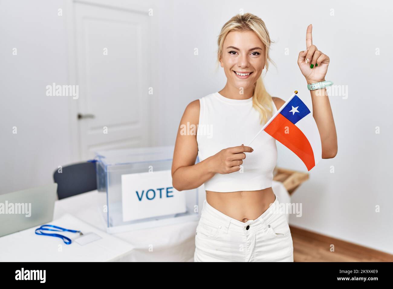 Young caucasian woman at political campaign election holding chile flag ...