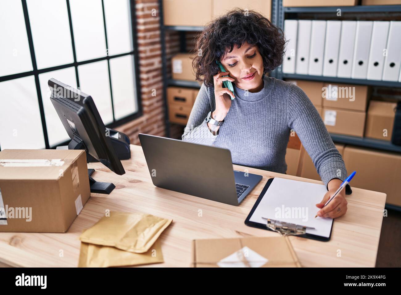 Young beautiful hispanic woman ecommerce business worker talking on ...