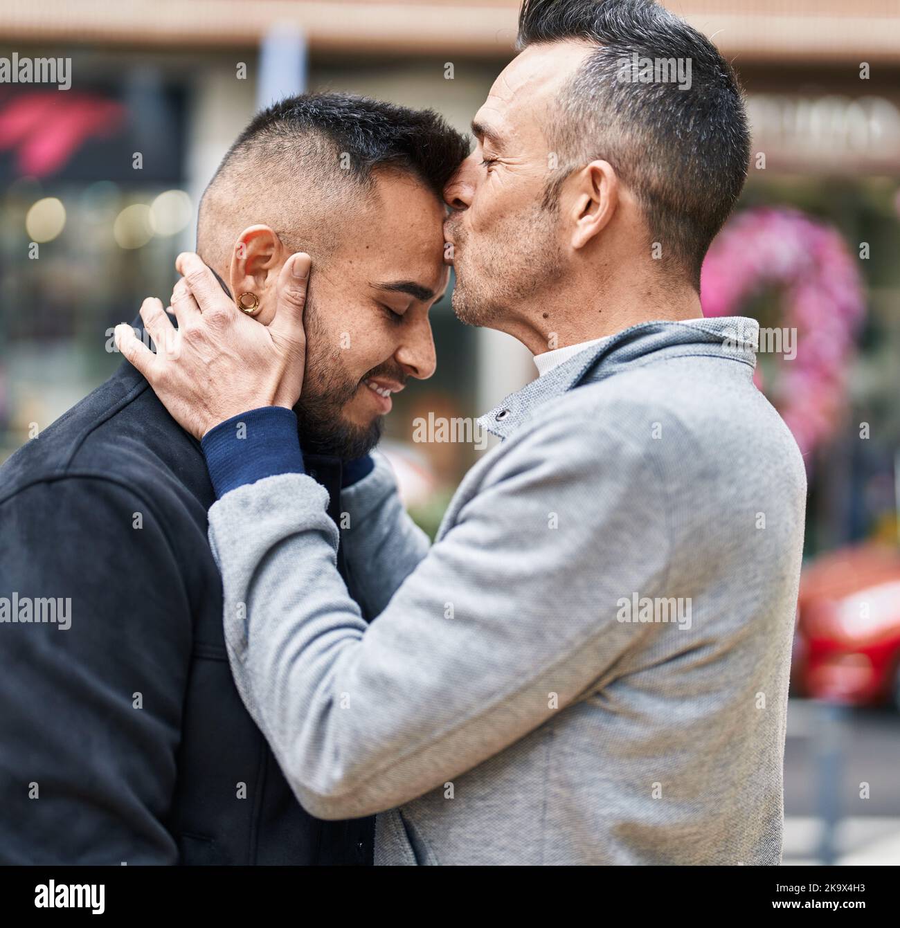 Two men couple hugging each other kissing at street Stock Photo - Alamy
