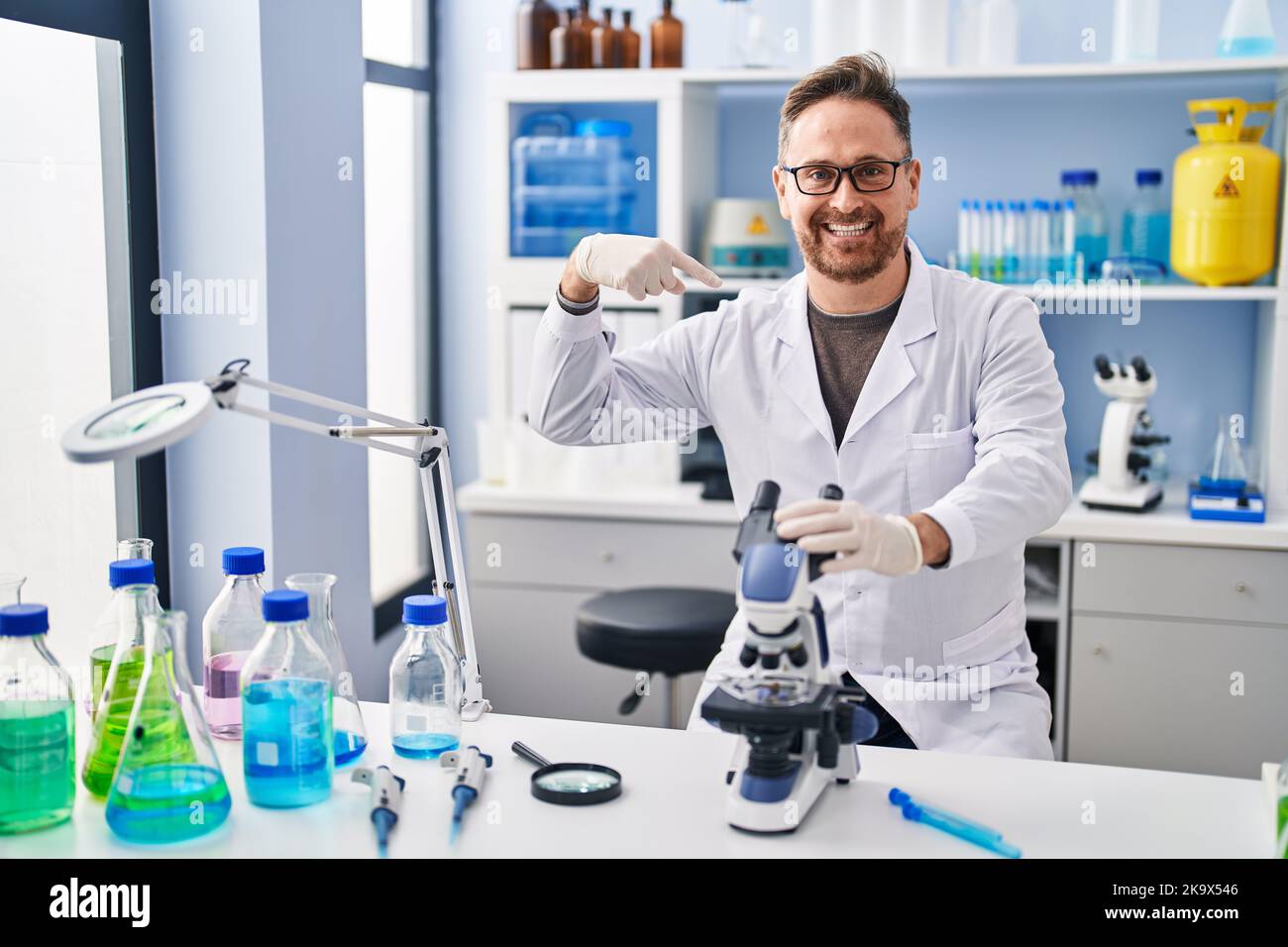 Middle age caucasian man working at scientist laboratory pointing ...