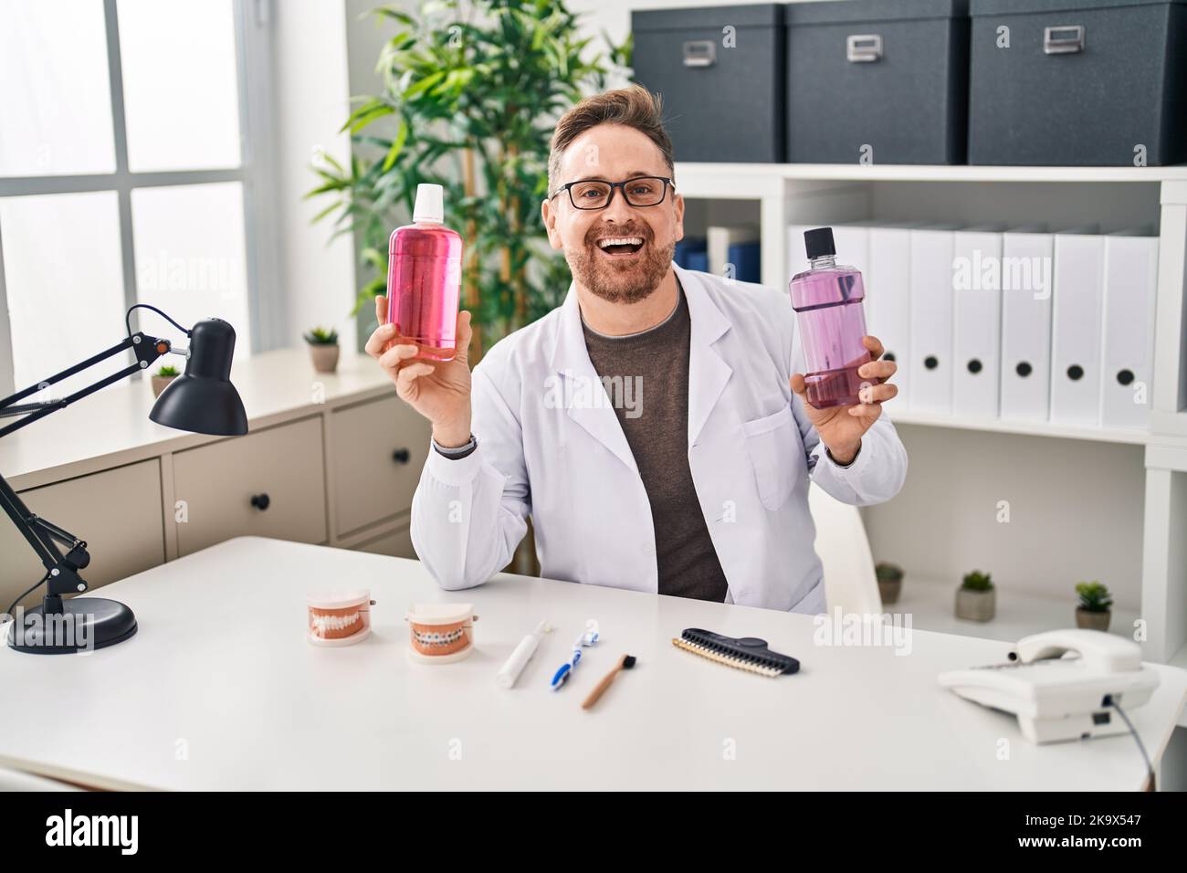 Middle age caucasian dentist man holding mouthwash for fresh breath ...