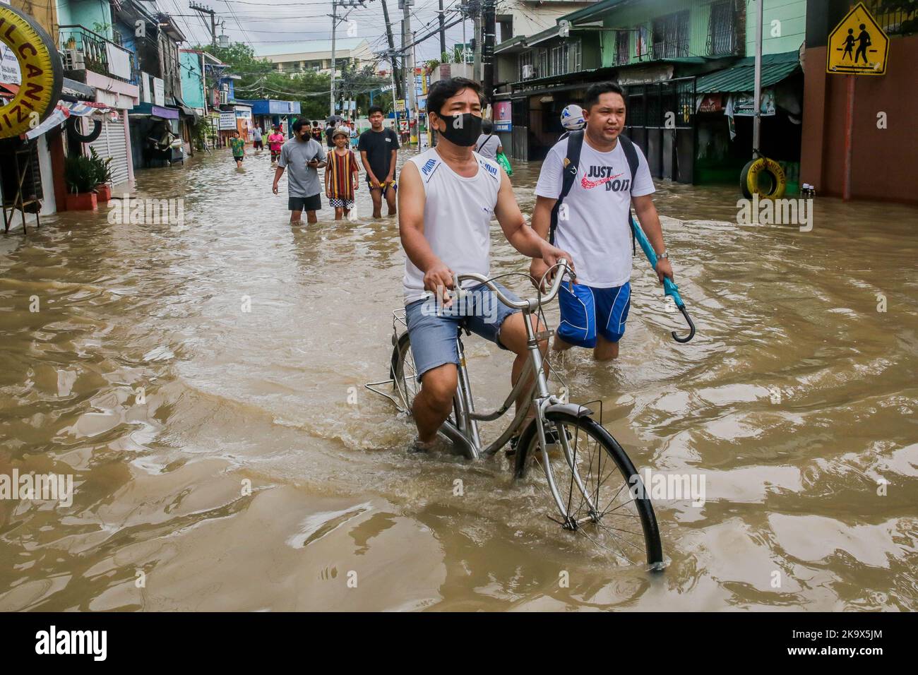 Cavite Province, Philippines. 30th Oct, 2022. Residents wade through ...