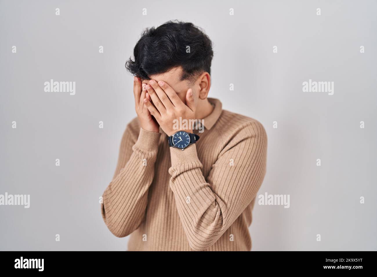 Non binary person standing over isolated background with sad expression ...
