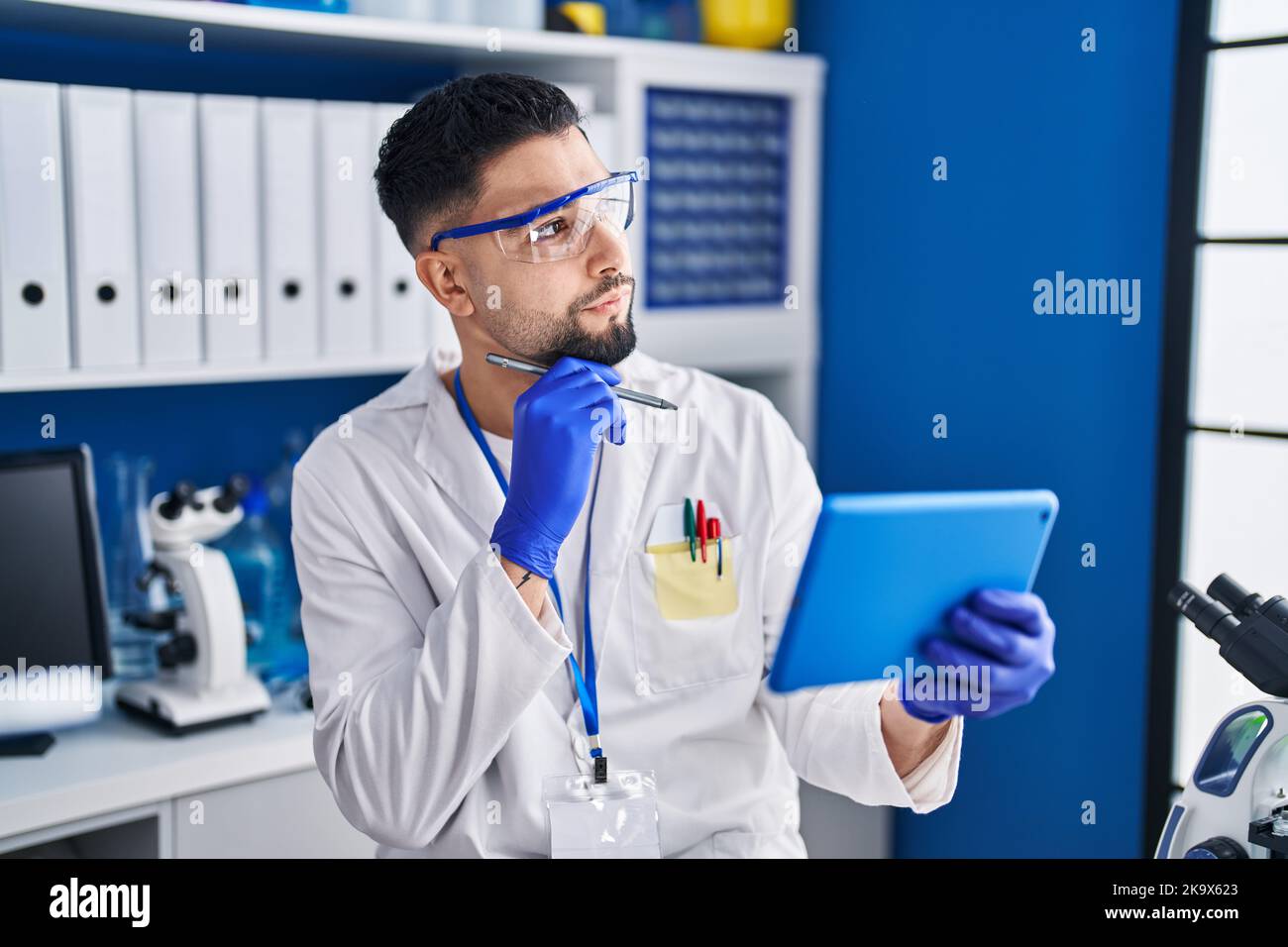 Young arab man scientist using touchpad working at laboratory Stock Photo - Alamy