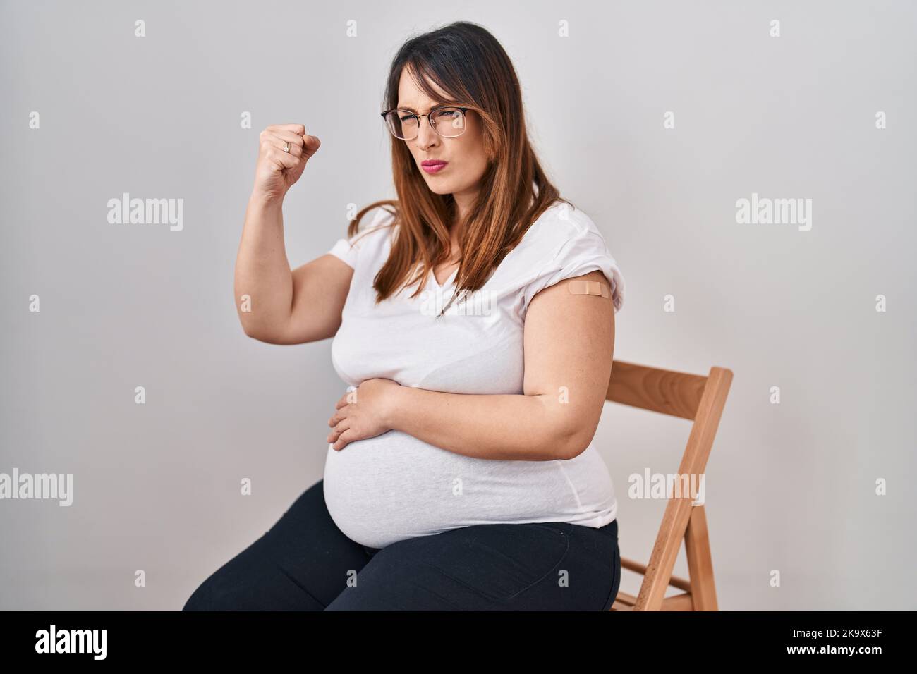 Pregnant woman wearing band aid for vaccine injection annoyed and ...