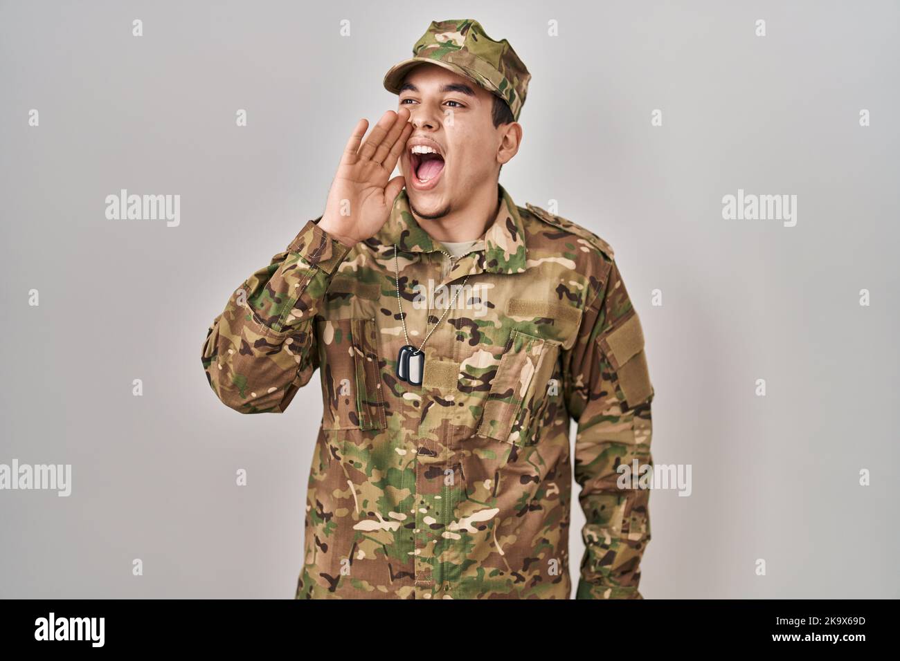 Young arab man wearing camouflage army uniform shouting and screaming ...