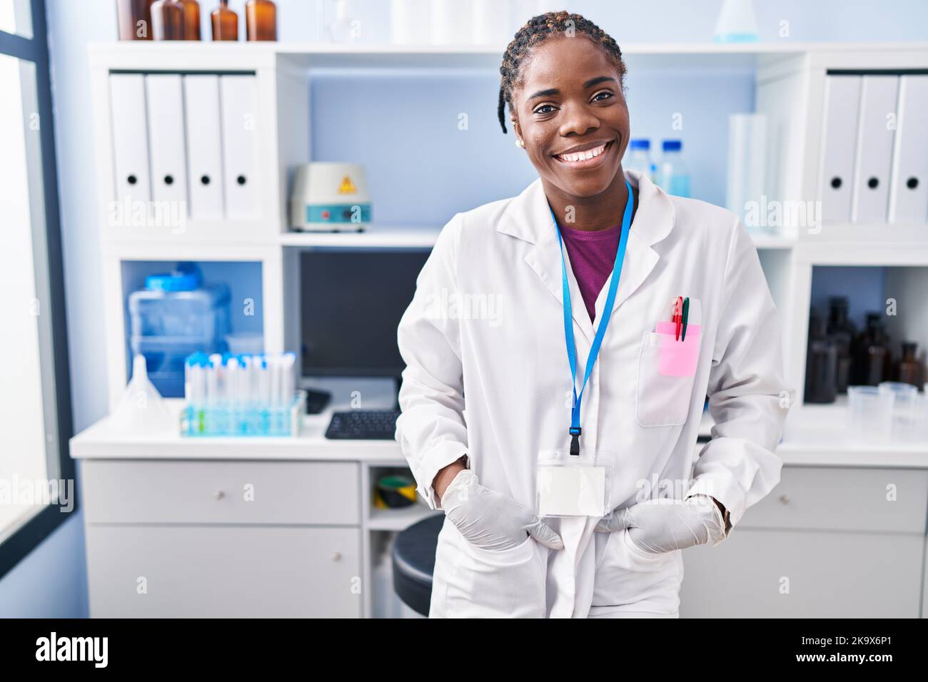 African american woman wearing scientist uniform standing at laboratory ...