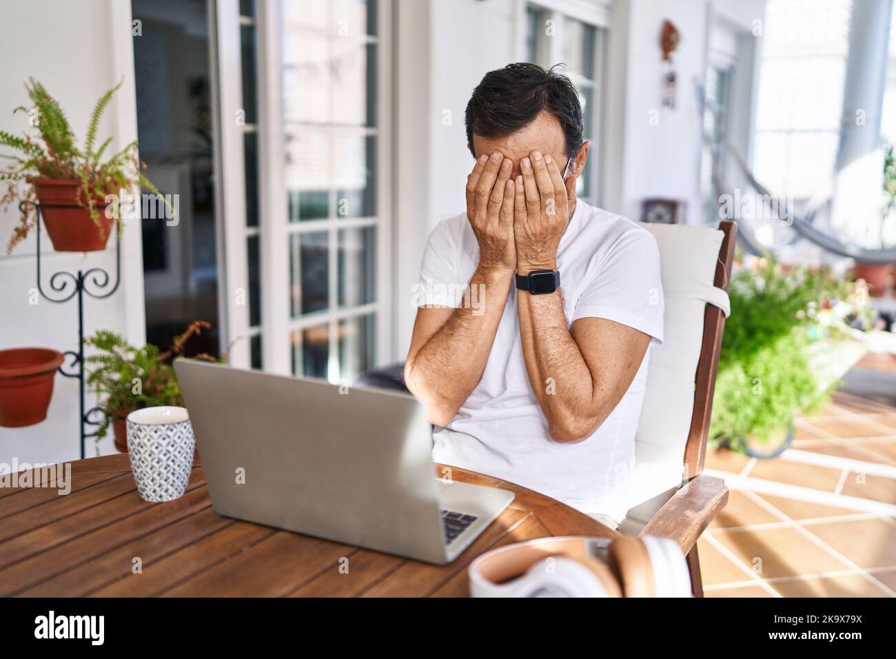 Middle age man using computer laptop at home with sad expression ...