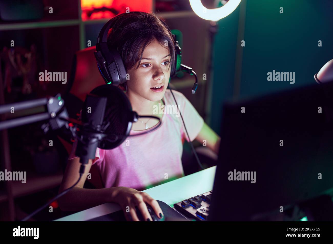 Adorable hispanic girl streamer playing video game using computer at ...