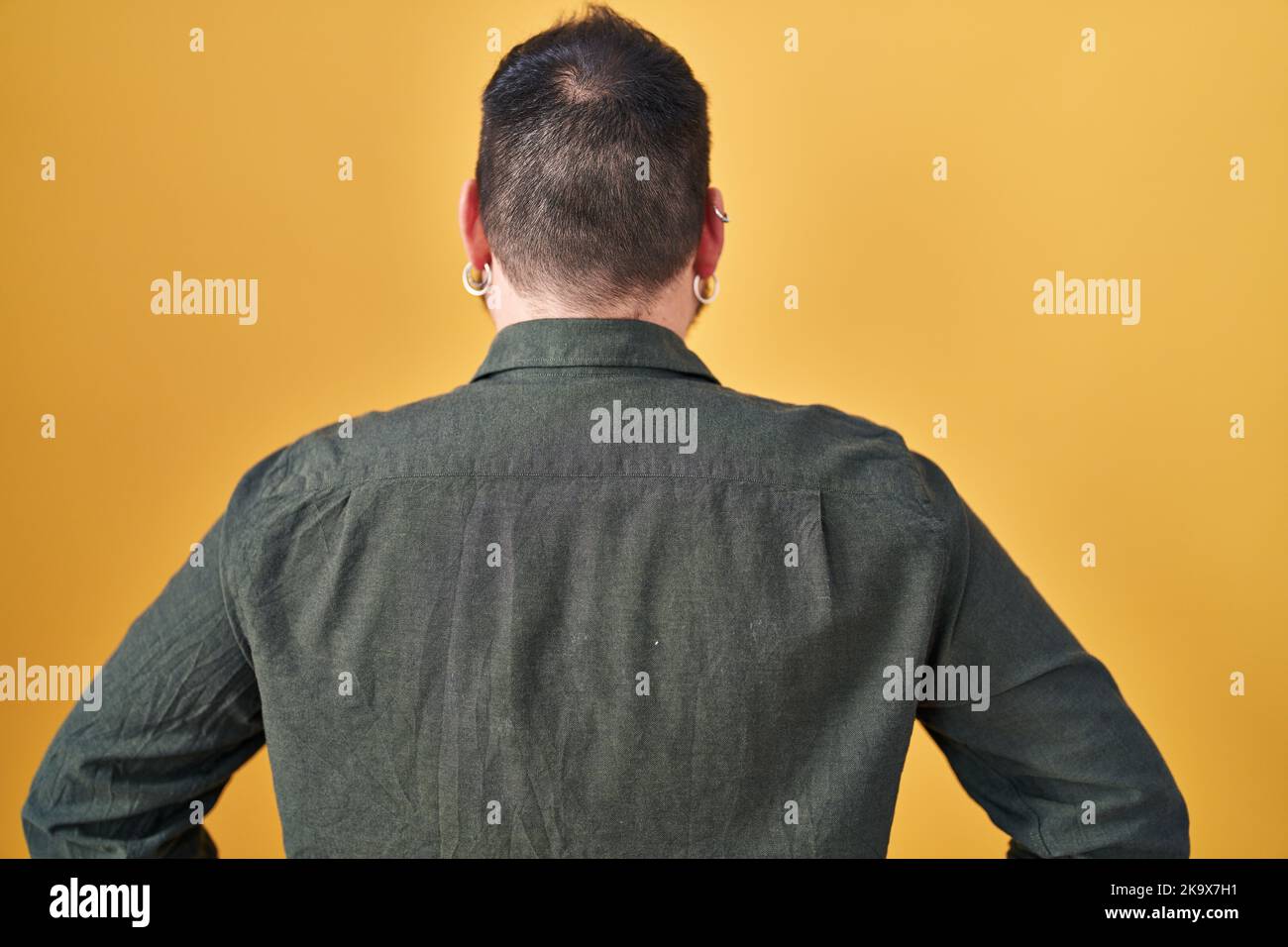 Plus size hispanic man with beard standing over yellow background ...