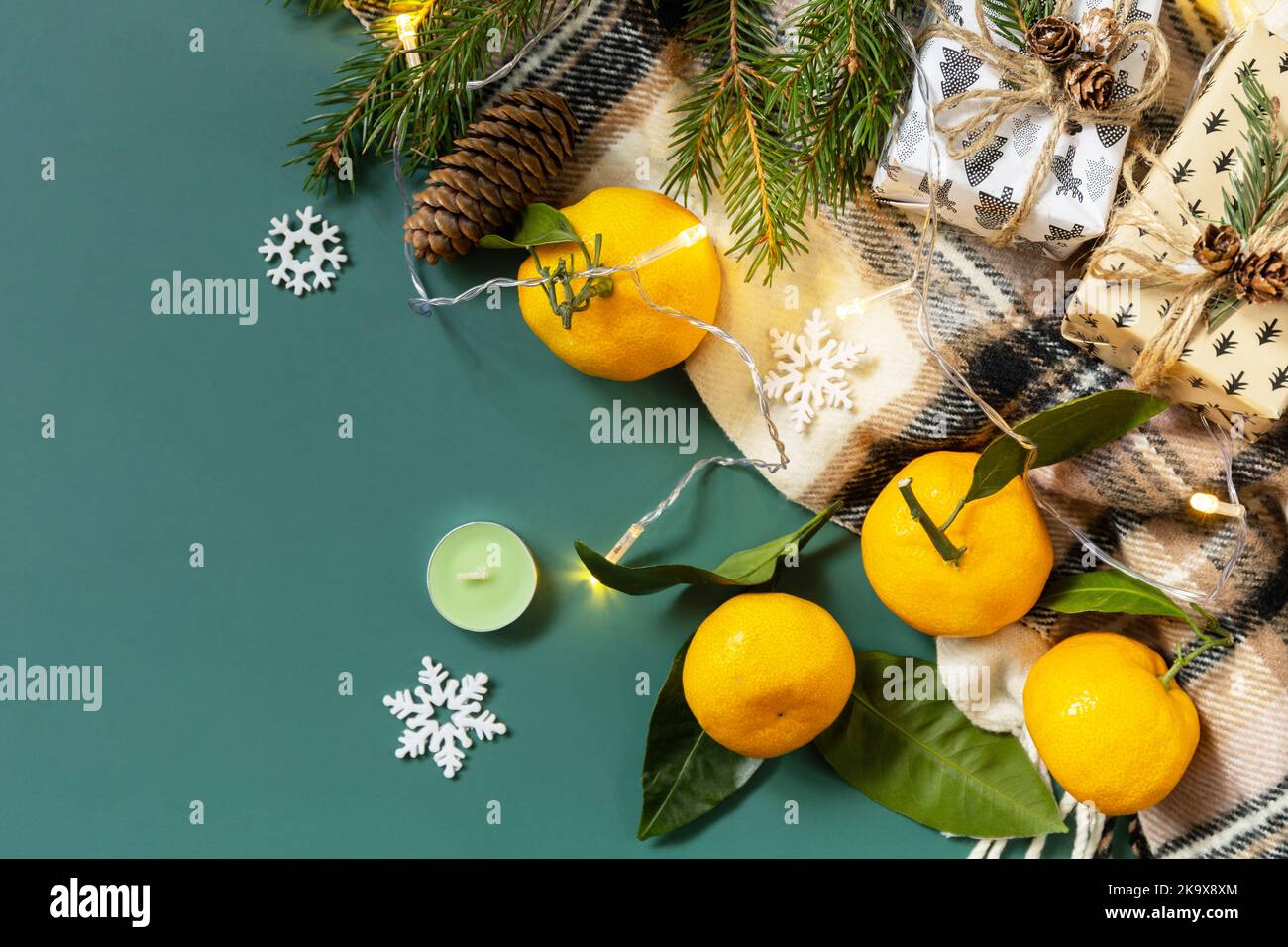 Winter composition with fir branches, present, scarf and tangerines on ...