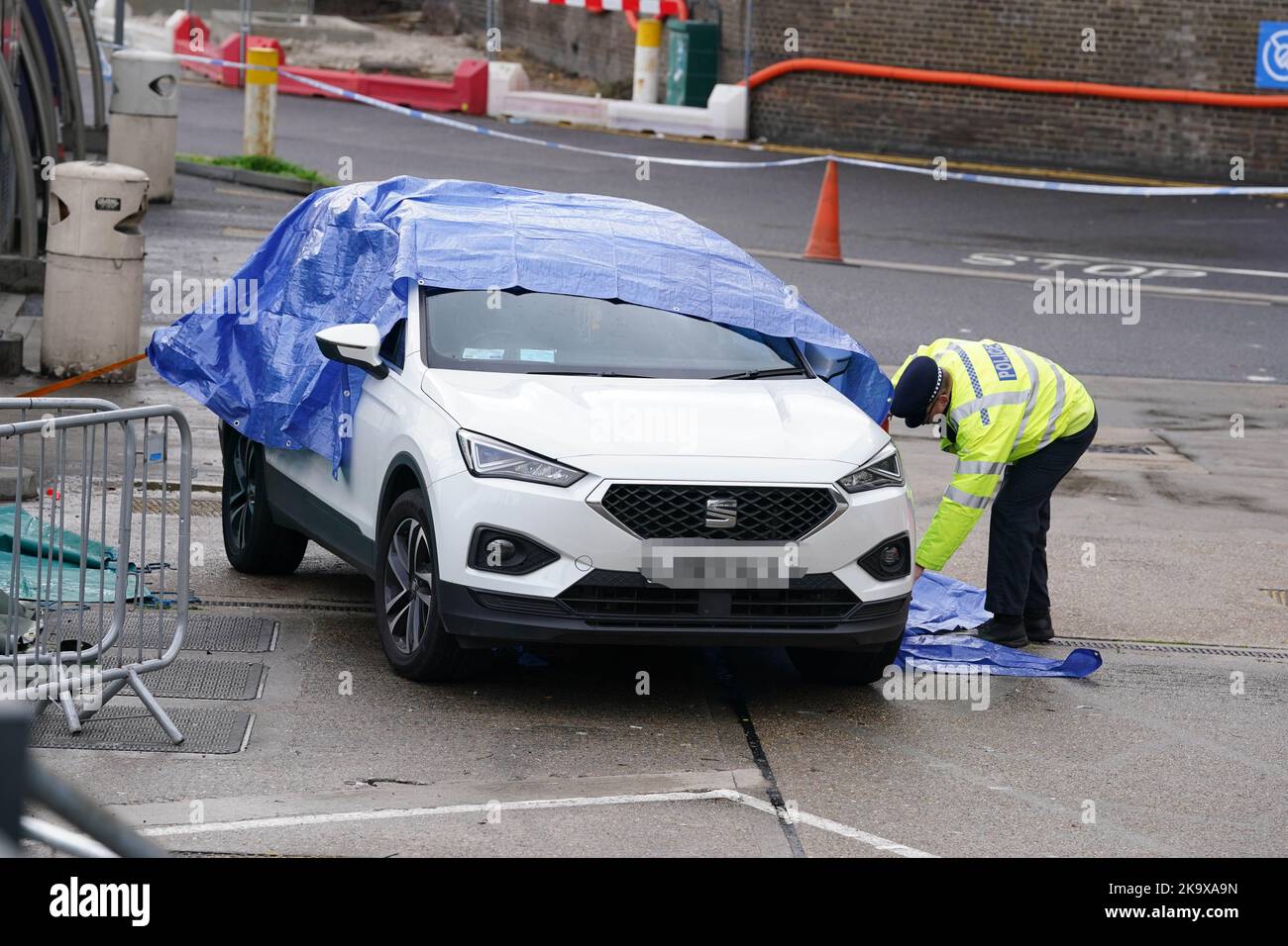 NUMBER PLATE PIXELATED BY PA PICTURE DESK A police officer covers the ...