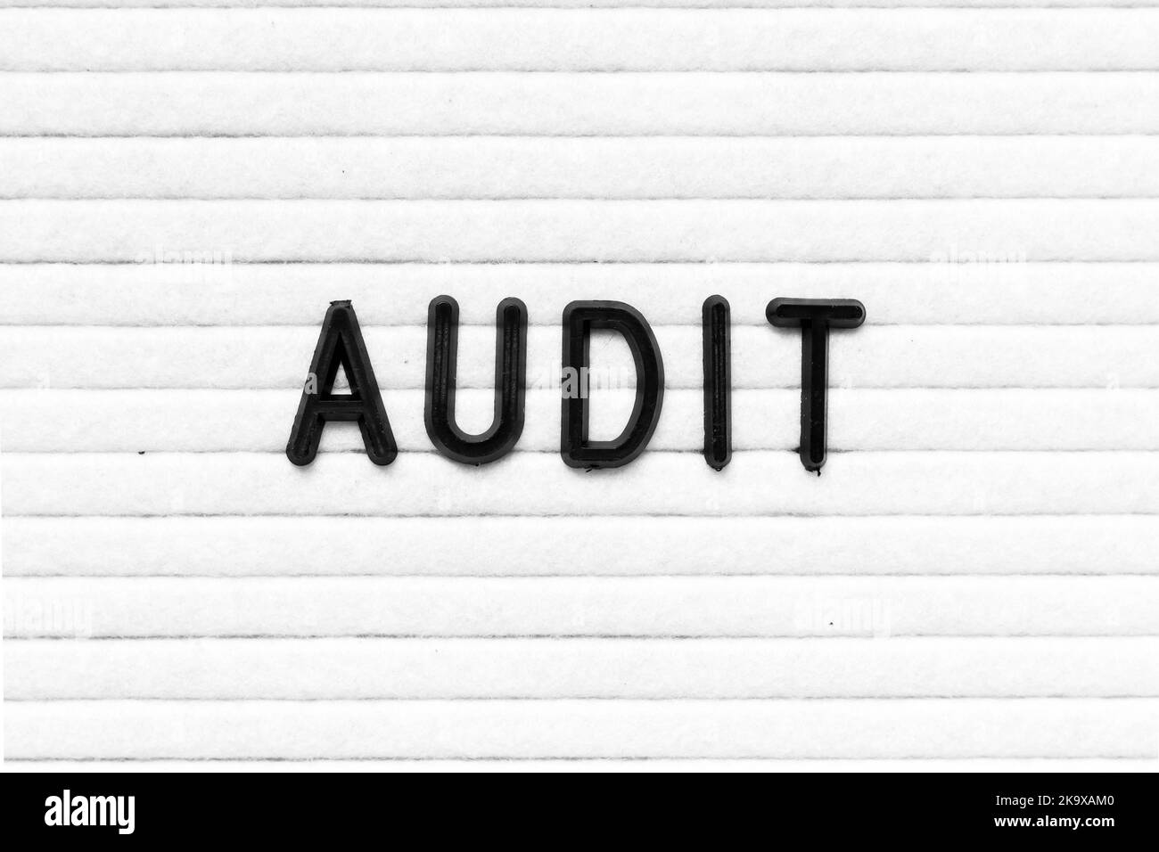 Black color letter in word audit on white felt board background Stock ...