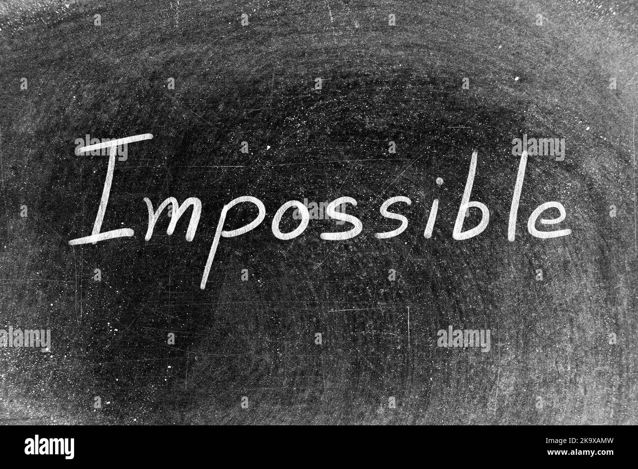 White chalk hand writing in word impossible on blackboard background ...