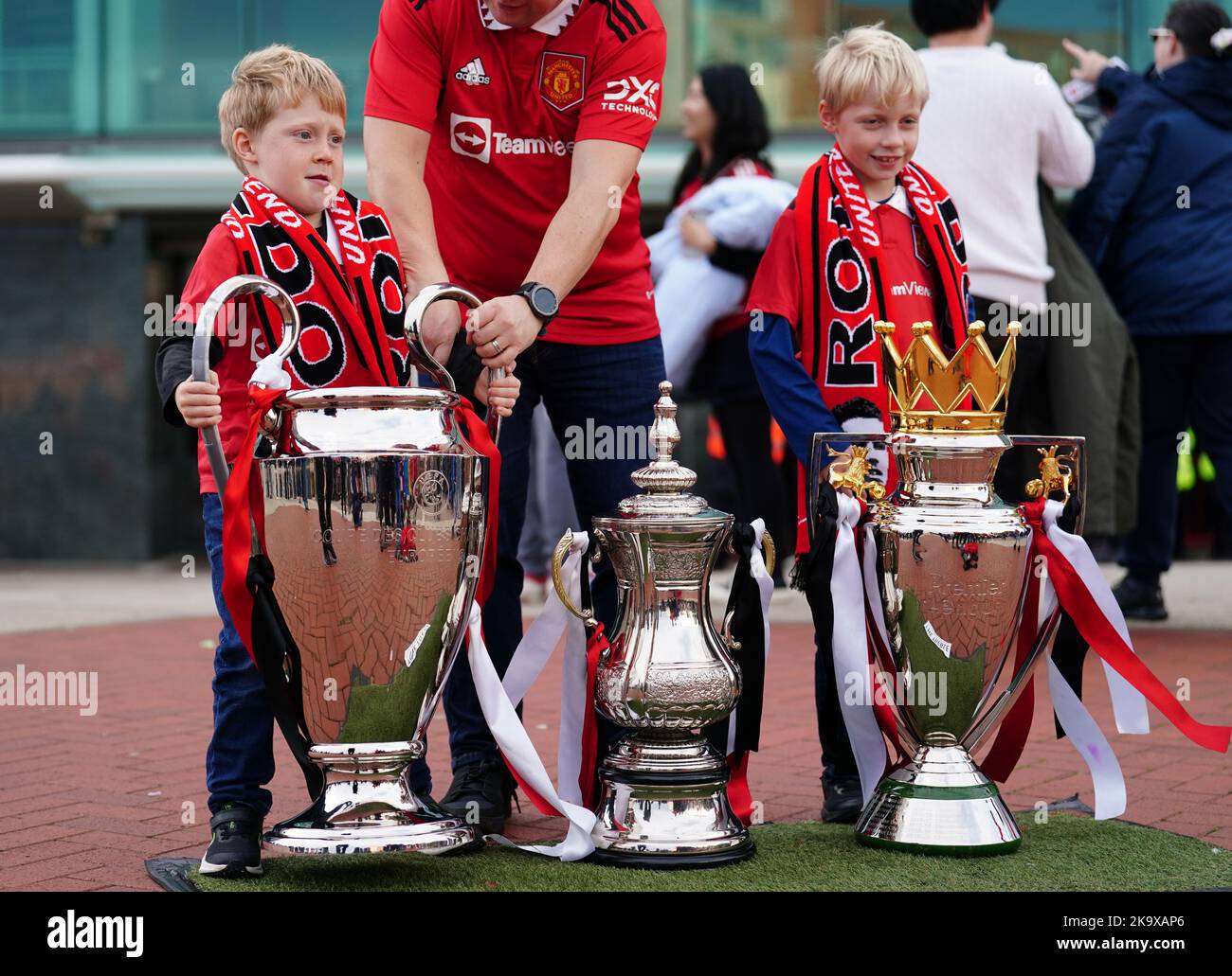 A fan poses with the European Champion Clubs' Cup, the FA Cup and the ...