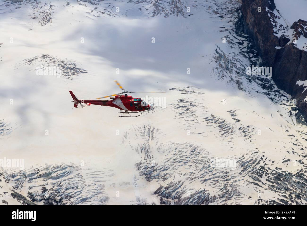 Helicopter flying over the snowy Swiss Alps in Switzerland Stock Photo ...