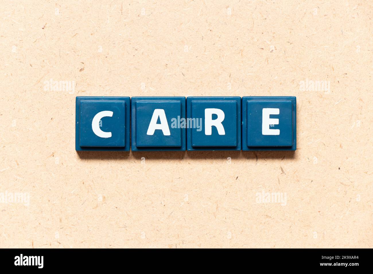 Tile letter in english word care on wood background Stock Photo - Alamy