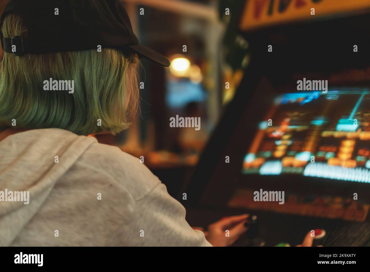 Teenage girl is playing arcade video game Stock Photo - Alamy