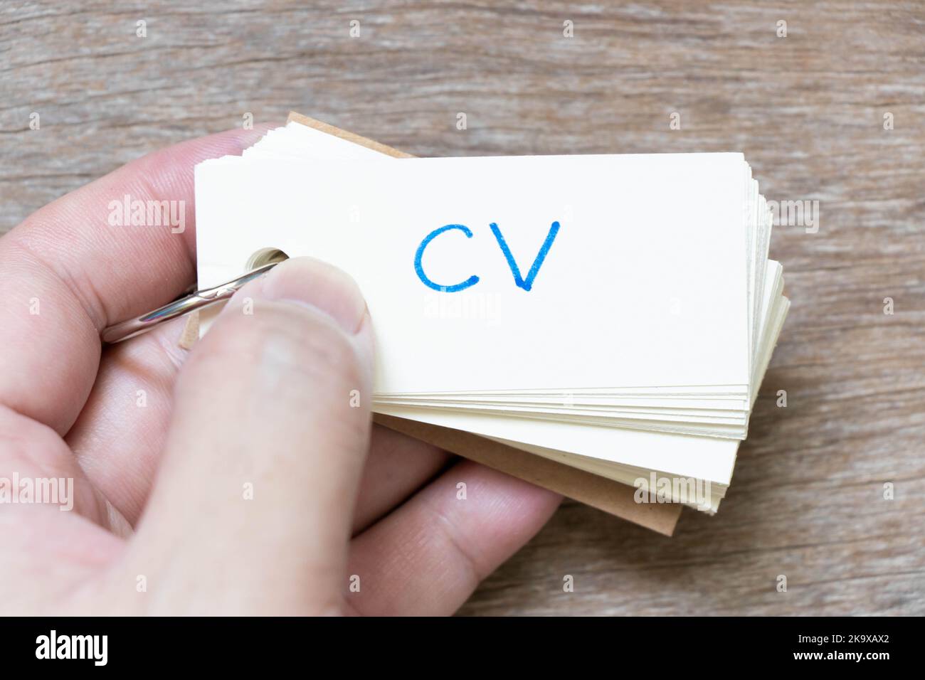 Hand hold flash card with handwriting in word CV (Abbreviation of ...