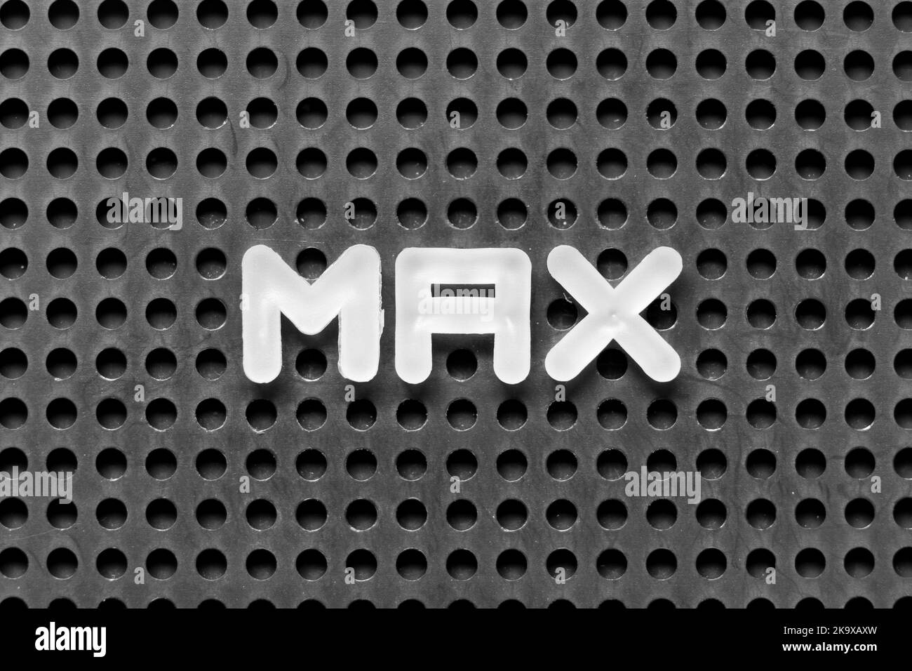 White alphabet letter in word max on black pegboard background Stock ...