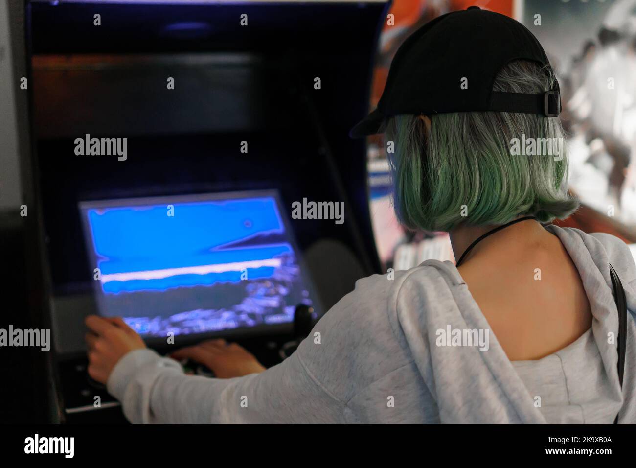 Teenage girl is playing arcade video game Stock Photo - Alamy