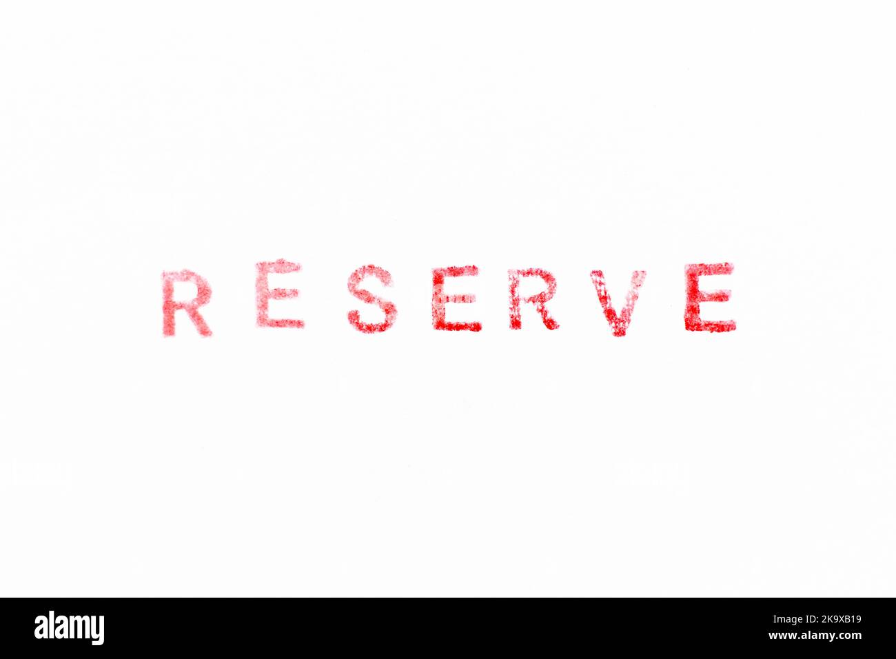 Red color ink rubber stamp in word reserve on white paper background ...