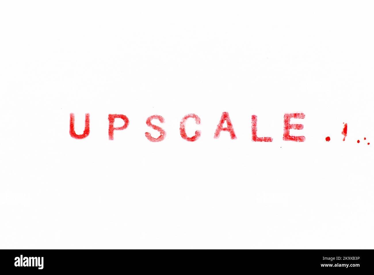 Red color ink rubber stamp in word upscale on white paper background ...