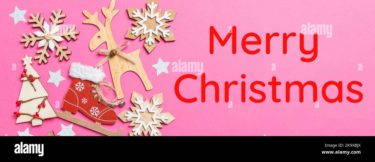 Merry Christmas text. Top view of pink background decorated with ...